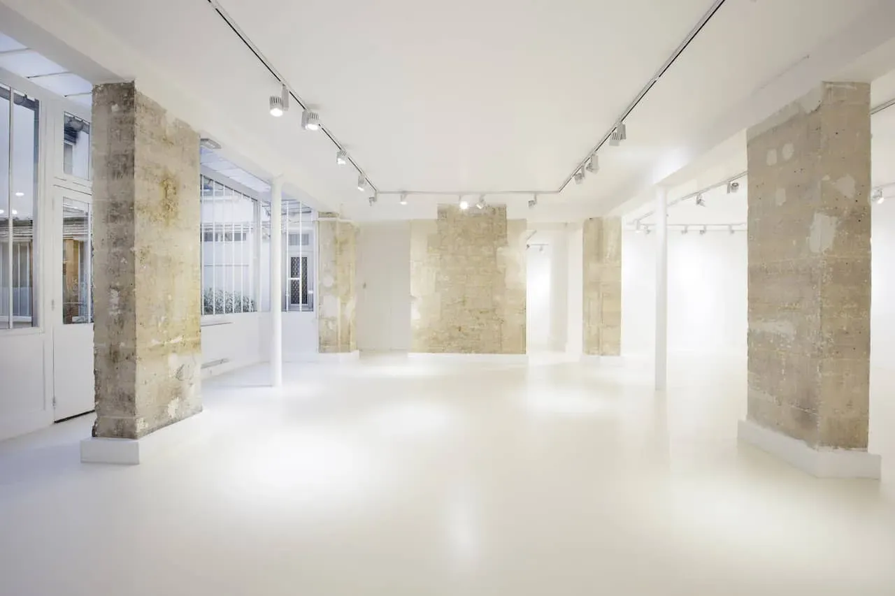 White Minimalistic Gallery With Exposed Stone Pillars for Artistic ...